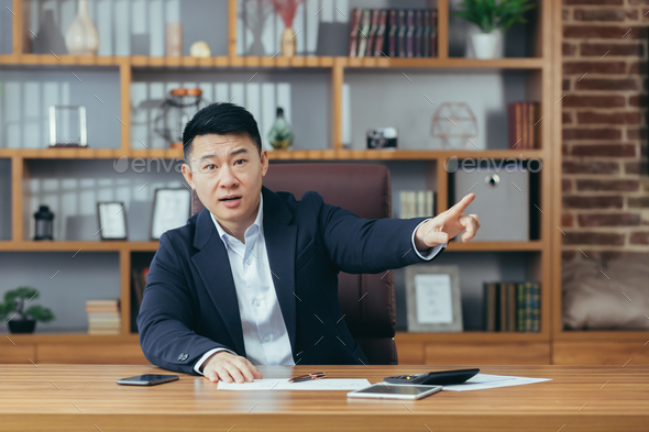 Asian angry businessman, boss fires employee looking at camera and ...