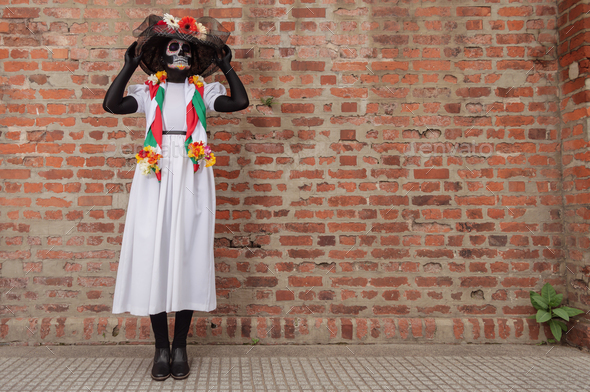 Full lengh view of a woman with white dress in a costume of Calavera ...