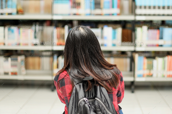 Back view of college student looking for the book at library Stock ...