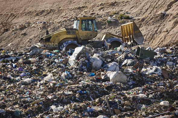 Heavy machinery shredding garbage in an open air landfill. Waste Stock ...