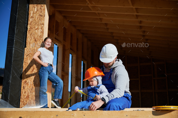 Father, mother and son building wooden frame house. Stock Photo by ...