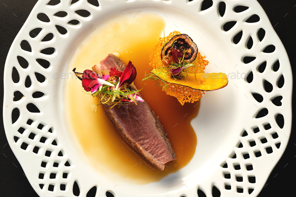 half-cooked lamb meat with vegetables, petals and sweet potato chips ...