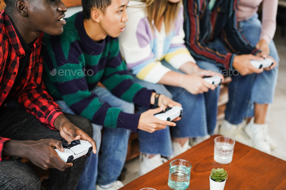 Multiracial young friends having fun playing video games at home Stock ...