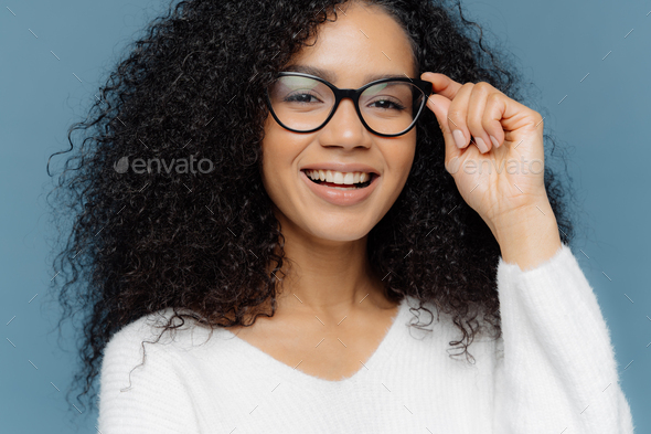 Cropped shot of good looking woman wears optical glasses, smiles ...
