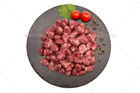 Raw rabbit heart meat on a round chopping board with black and red ...