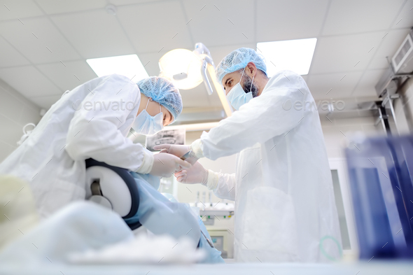 Surgeons during a dental operation.Anesthetized patient in the ...