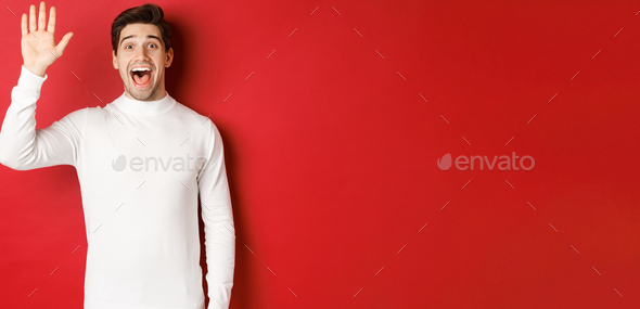 Image of happy and friendly young man saying hello, waving hand to ...