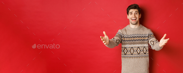 Image of happy and flattered handsome guy in christmas sweater ...