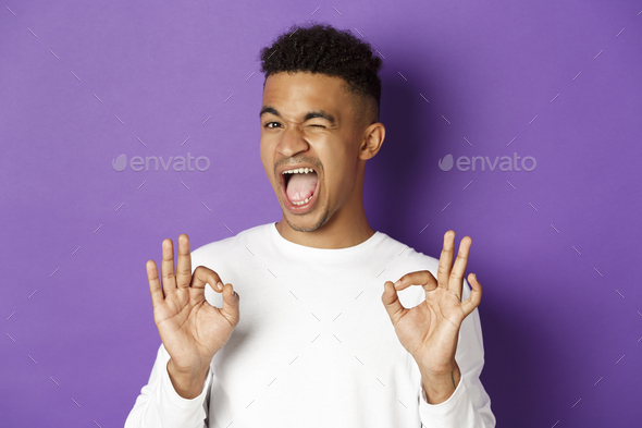 Cheeky african-american man winking, ensure you in something, showing ...