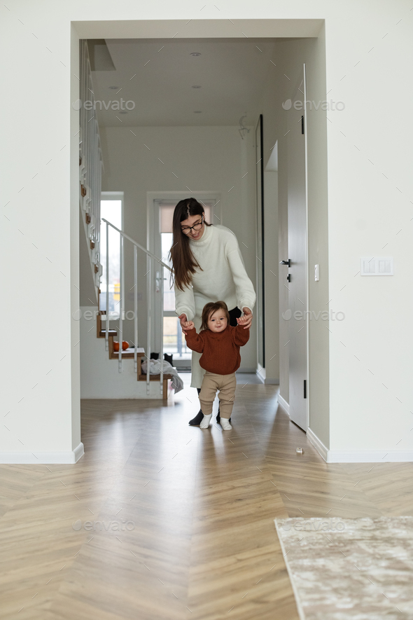 Adorable kid holding mother's hands, little daughter walking down ...