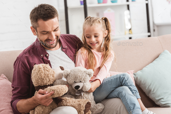 father and daughter playing with teddy bears on father knees Stock ...