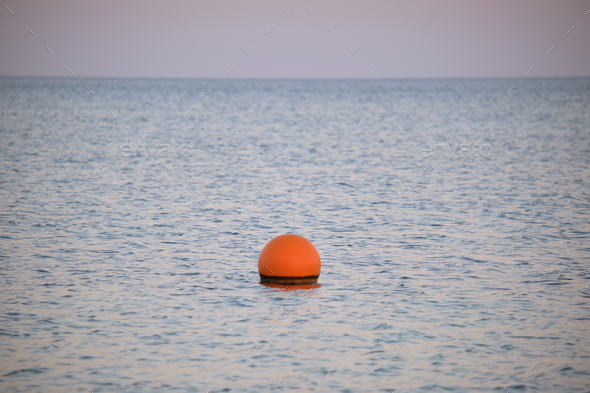 Orange buoy floating on sea surface waves. Human life safety concept ...