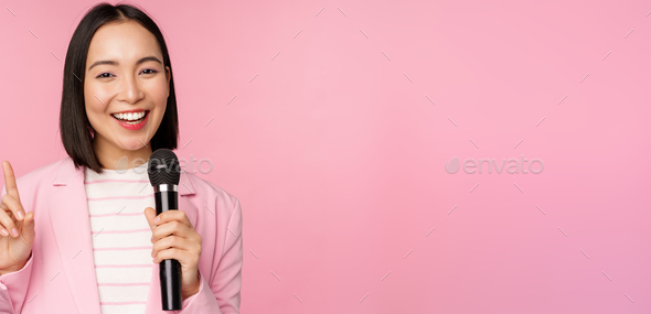 Image of enthusiastic asian businesswoman giving speech, talking with ...