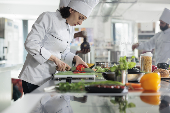 Sous chef chopping red pepper vegetable for gourmet dish served at ...