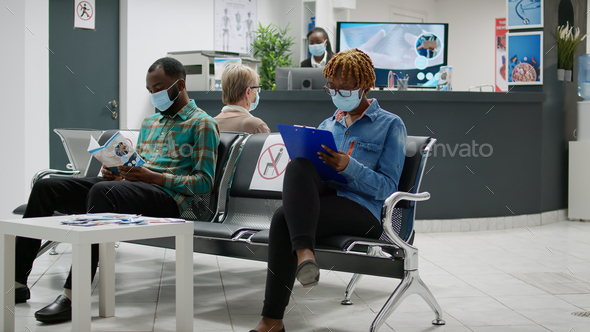 Multiethnic group of people sitting in waiting area during covid 19 ...