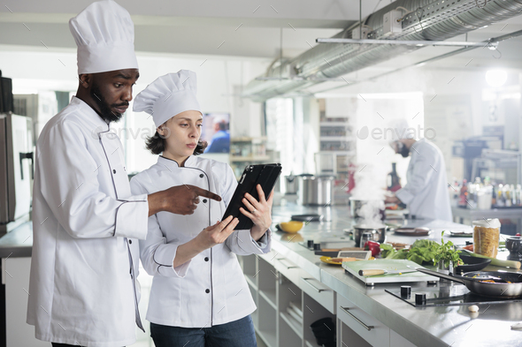 Food industry worker with handheld touchscreen device preparing ...