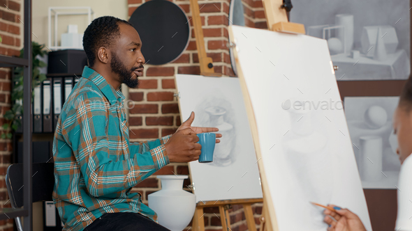 Young teacher explaining drawing skills at art class lesson Stock Photo ...