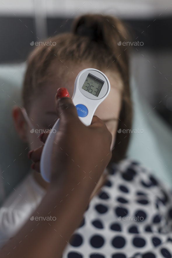 Close up shot of african american nurse measuring sick little girl body ...