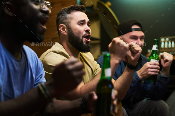 Group of football fans expressing joy and shouting excitedly during ...