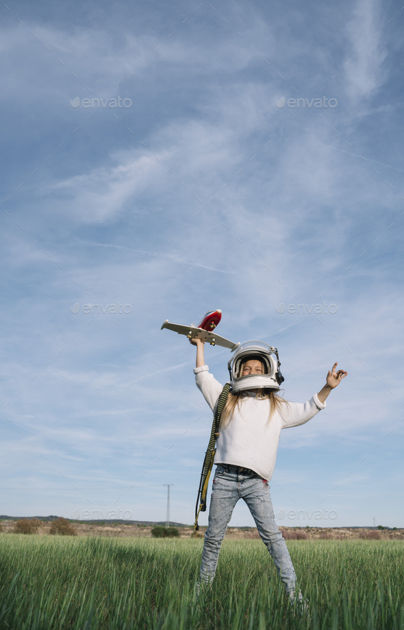 Adorable little girl wearing a helmet and playing alone with a space ...