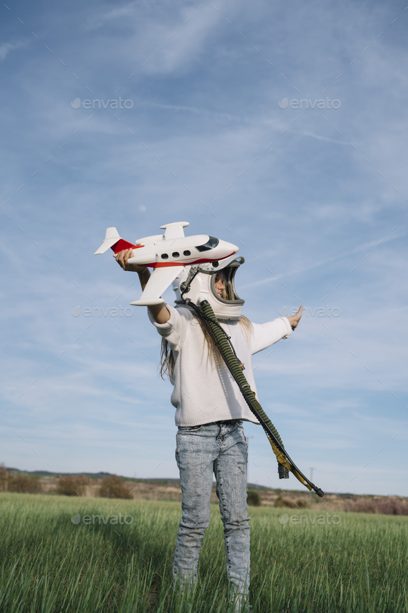 Adorable little girl wearing a helmet and playing alone with a space ...