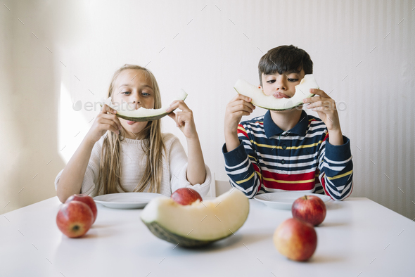 Little kids eating fruit in the house Stock Photo by karrastock | PhotoDune