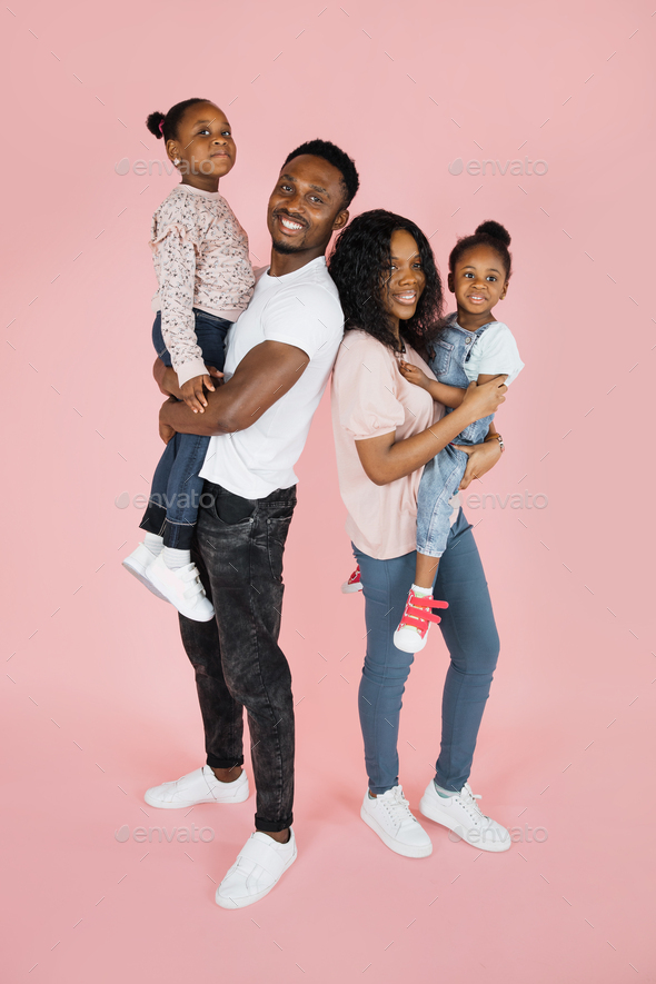 Happy african parents and two daughters embracing each other standing ...