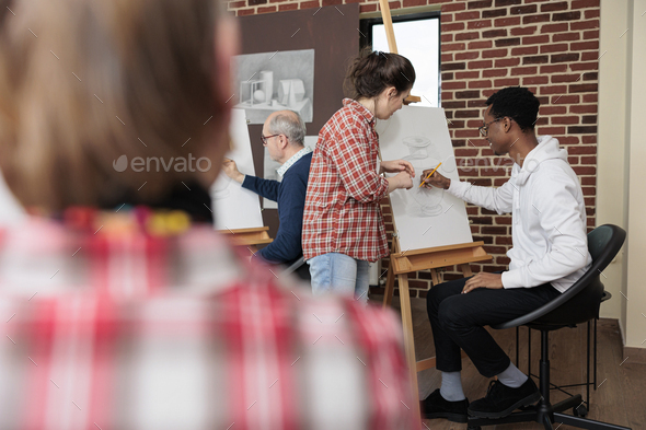 Artist teacher explaining drawing process to young student Stock Photo ...