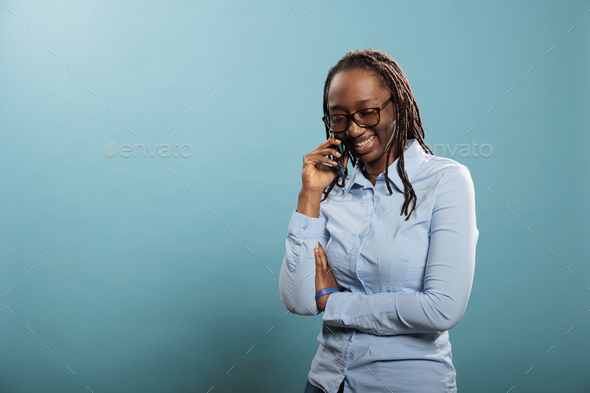 Happy joyful young woman smiling heartily while having a phone call ...