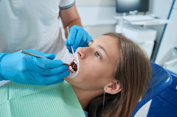 Stomatologist inspecting oral cavity of young patient Stock Photo by ...