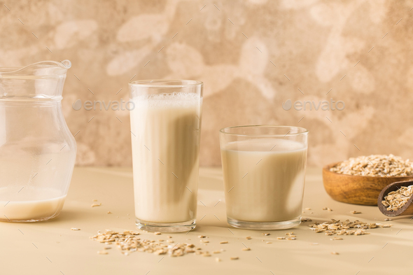 A glass of oat milk, a jug and oat flakes. The concept of alternative ...