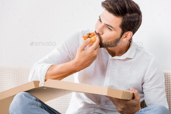 portrait of young man eating pizza alone at home Stock Photo by ...