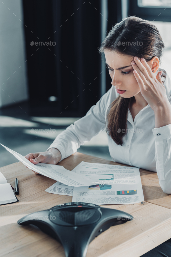 confused young businesswoman doing paperwork at modern office Stock ...