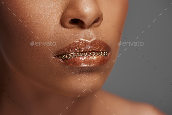 cropped shot of african american woman with chain on lips isolated on ...