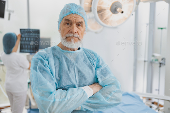 Professional surgeon standing in operating room with crossing hands ...