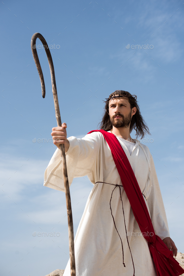 Jesus in robe, red sash and crown of thorns standing with wooden staff ...