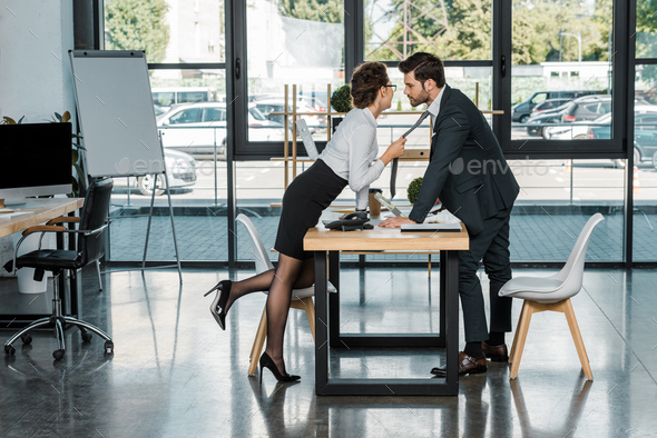 side view of businessman and businesswoman flirting at workplace in office Stock Photo by ...