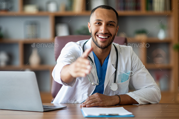 Cheerful middle eastern doc greeting patient at clinic Stock Photo by ...