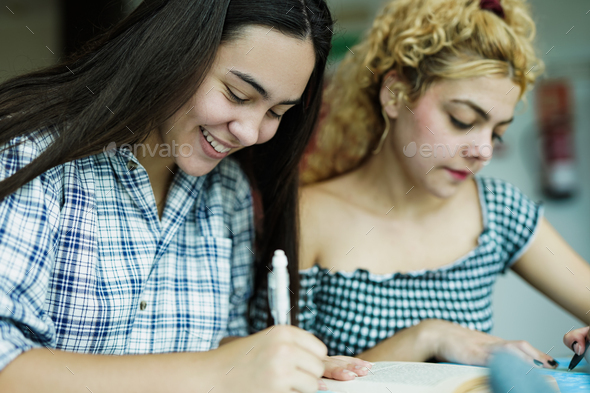 Young diverse students learning together inside university library ...