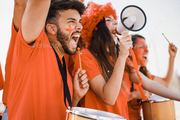 Orange sport fans screaming while supporting their team out of the ...