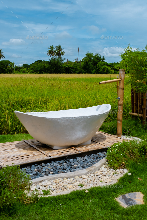 white bath tub outside on vacation at a homestay in Thailand with green ...