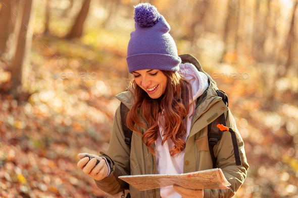 Woman reading a map and checking compass while hiking Stock Photo by ...