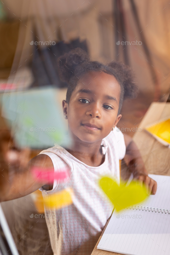 Little girl writing on sticky notes Stock Photo by Impactphotography