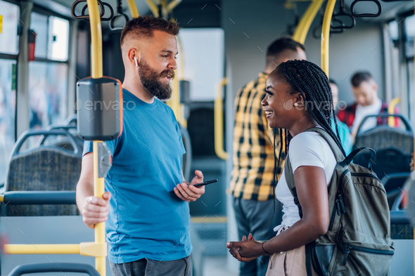 Multiracial friends talking while riding a bus in the city Stock Photo ...