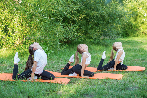Children play sports in park using fitness mats. Training with ...