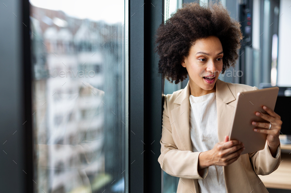 Happy business woman manager holding tablet and working in modern ...