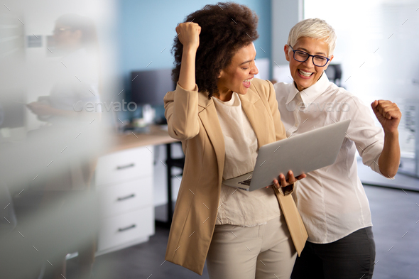 Happy multiethnic smiling business women working together in office Stock Photo by nd3000