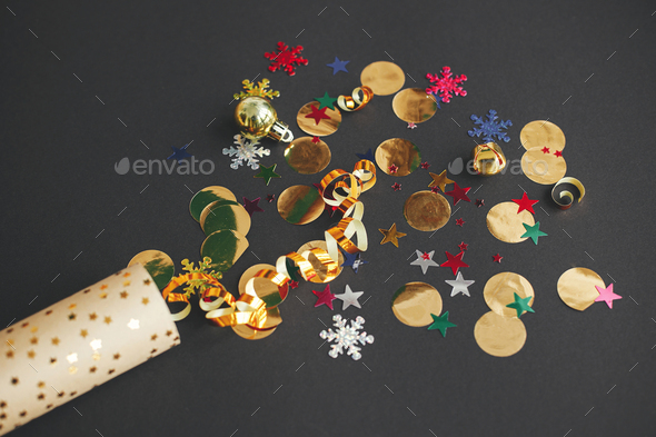 Modern colorful confetti popping from golden wrapping paper on black ...