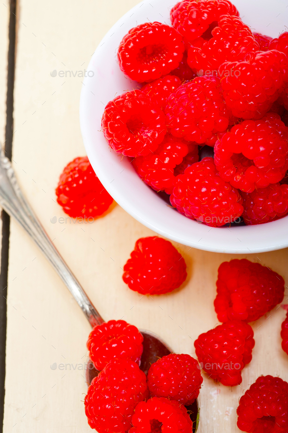 bunch of fresh raspberry on a bowl and white table Stock Photo by keko64