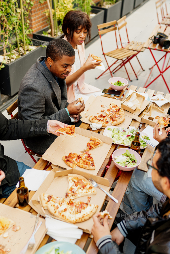 Top View Of Multiracial Group Of Friends Sharing Food Together At A